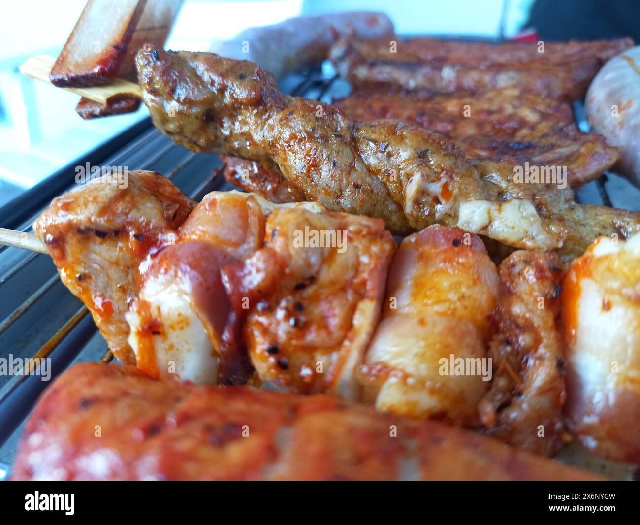Grillgut auf einem Tischgrill im eigenen Garten. Grillsaison 2024 ...