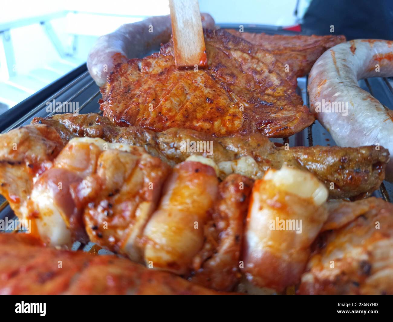 Grillgut auf einem Tischgrill im eigenen Garten. Grillsaison 2024 ...