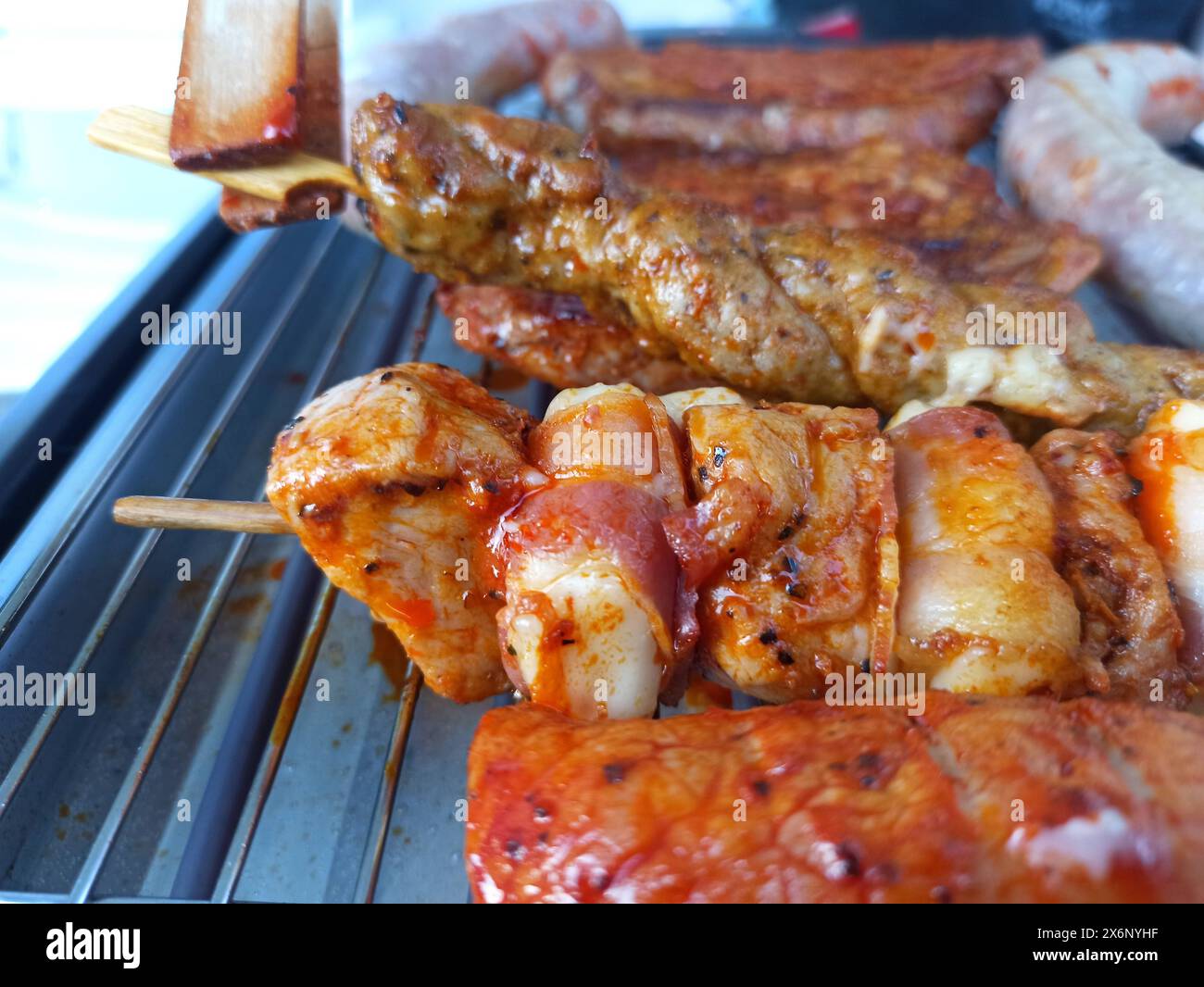 Grillgut auf einem Tischgrill im eigenen Garten. Grillsaison 2024 ...