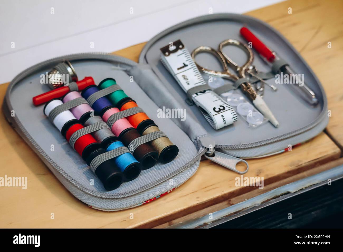 Sewing kit including colored thread, scissors, measuring tape, pins and ...