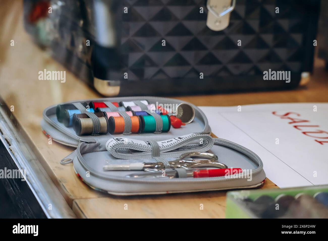 Sewing kit including colored thread, scissors, measuring tape, pins and ...