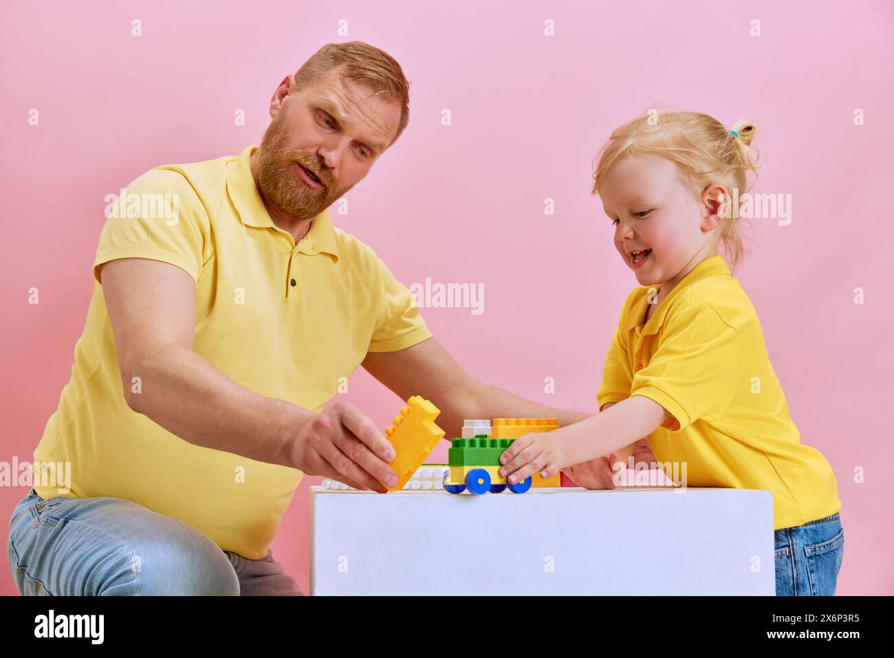 Playtime construction fun. Dad and his daughter share playful bonding activity, assembling ...