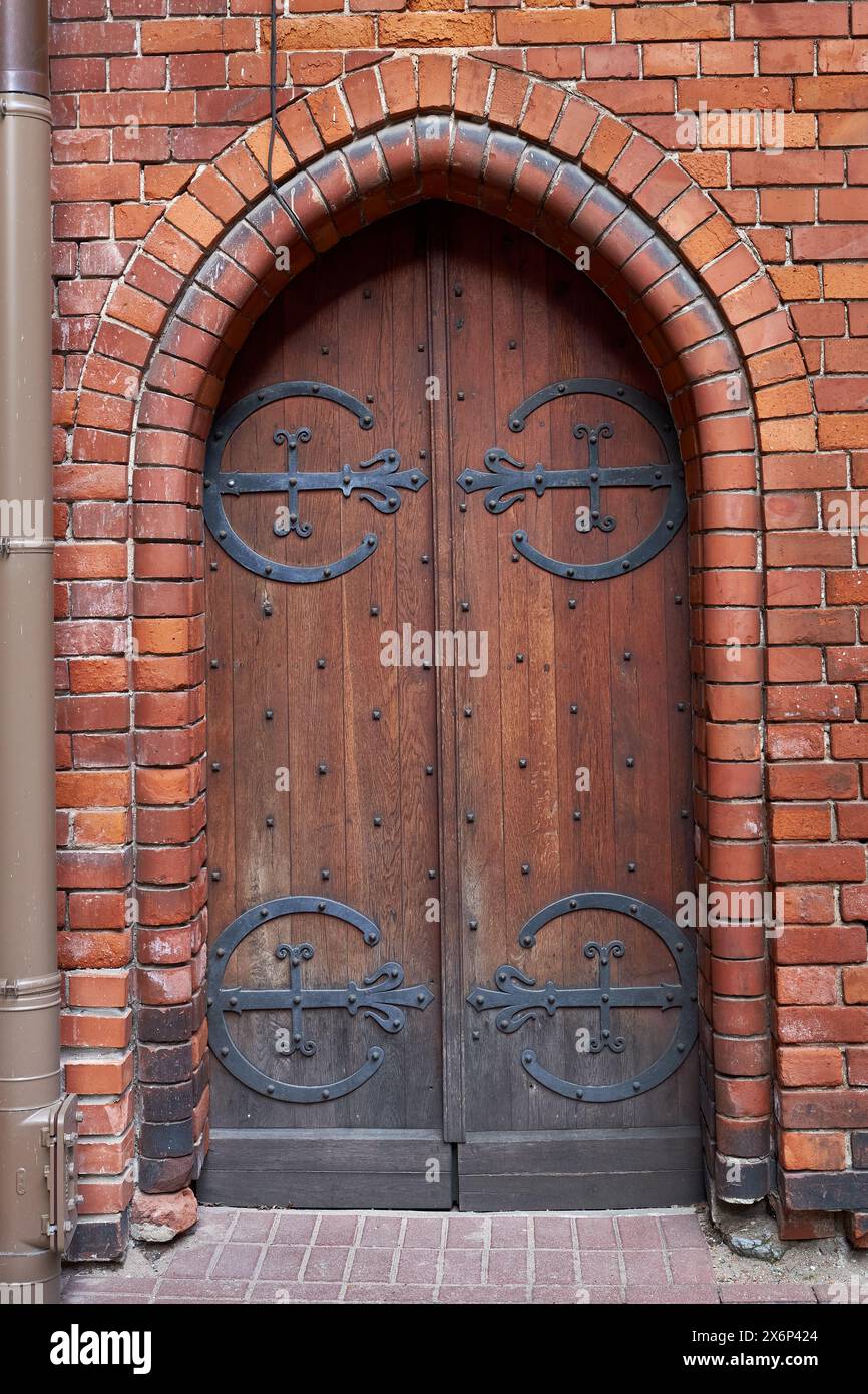 Old vintage wooden gothic door on a medieval brick building facade ...