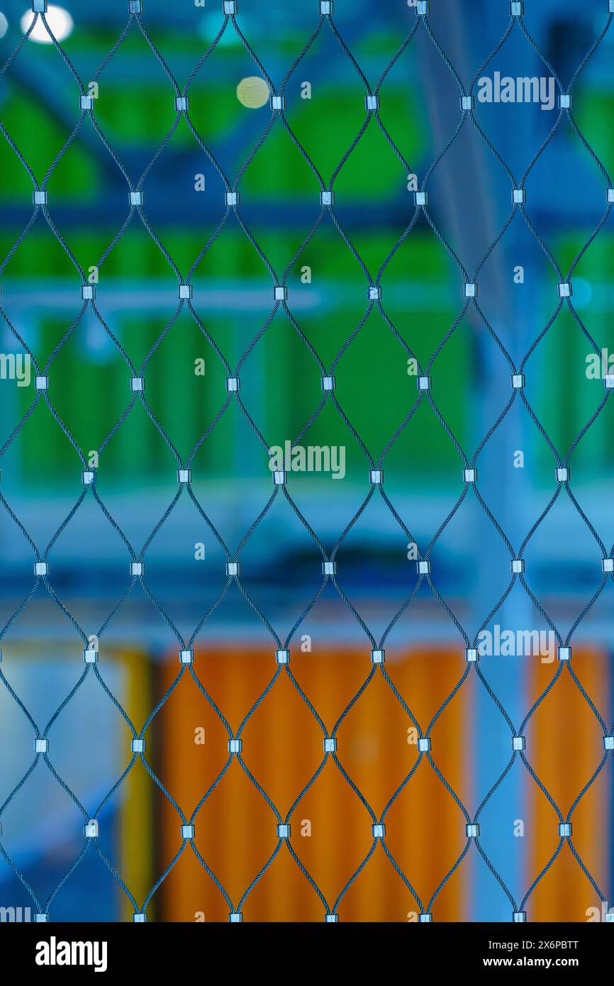 View of warehouse building with closeup of a fence grid, and colorful ...