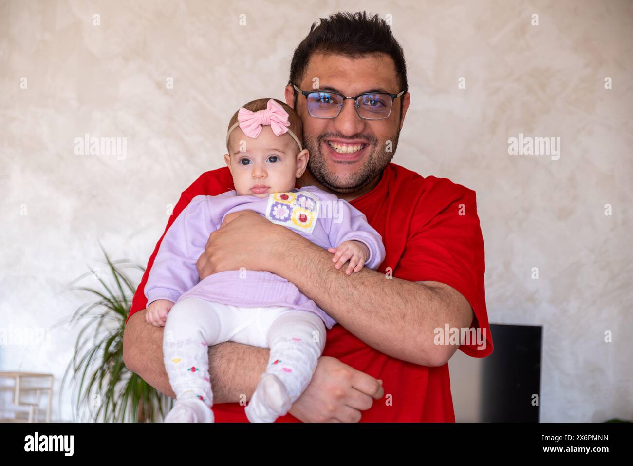 uncle holding his brothers daughter feeling playing with her and ...
