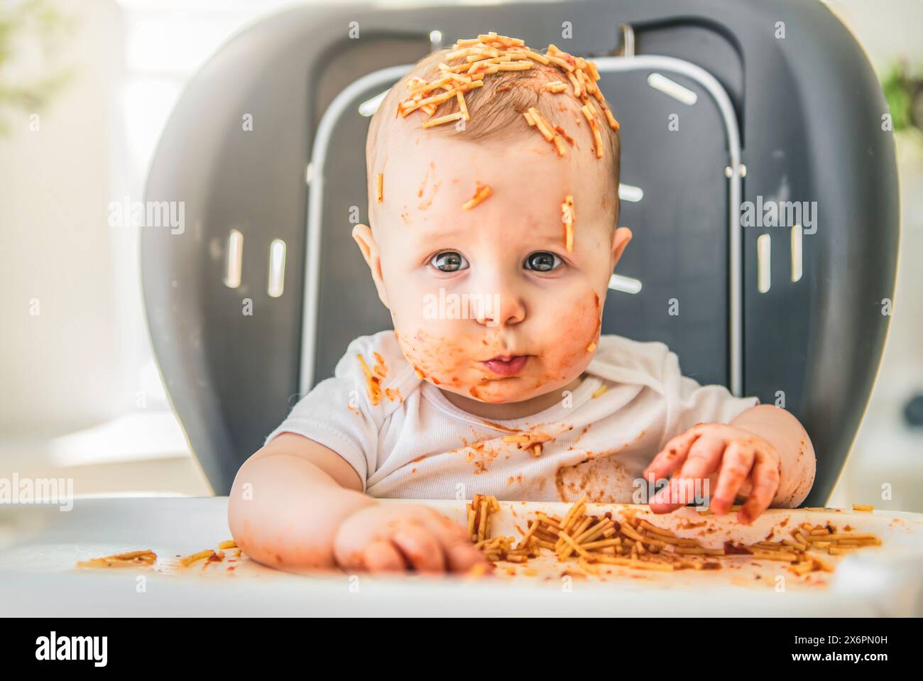 Little baby eating her dinner and making a mess Stock Photo - Alamy