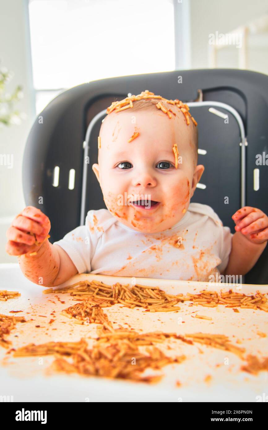 Little baby eating her dinner and making a mess Stock Photo - Alamy