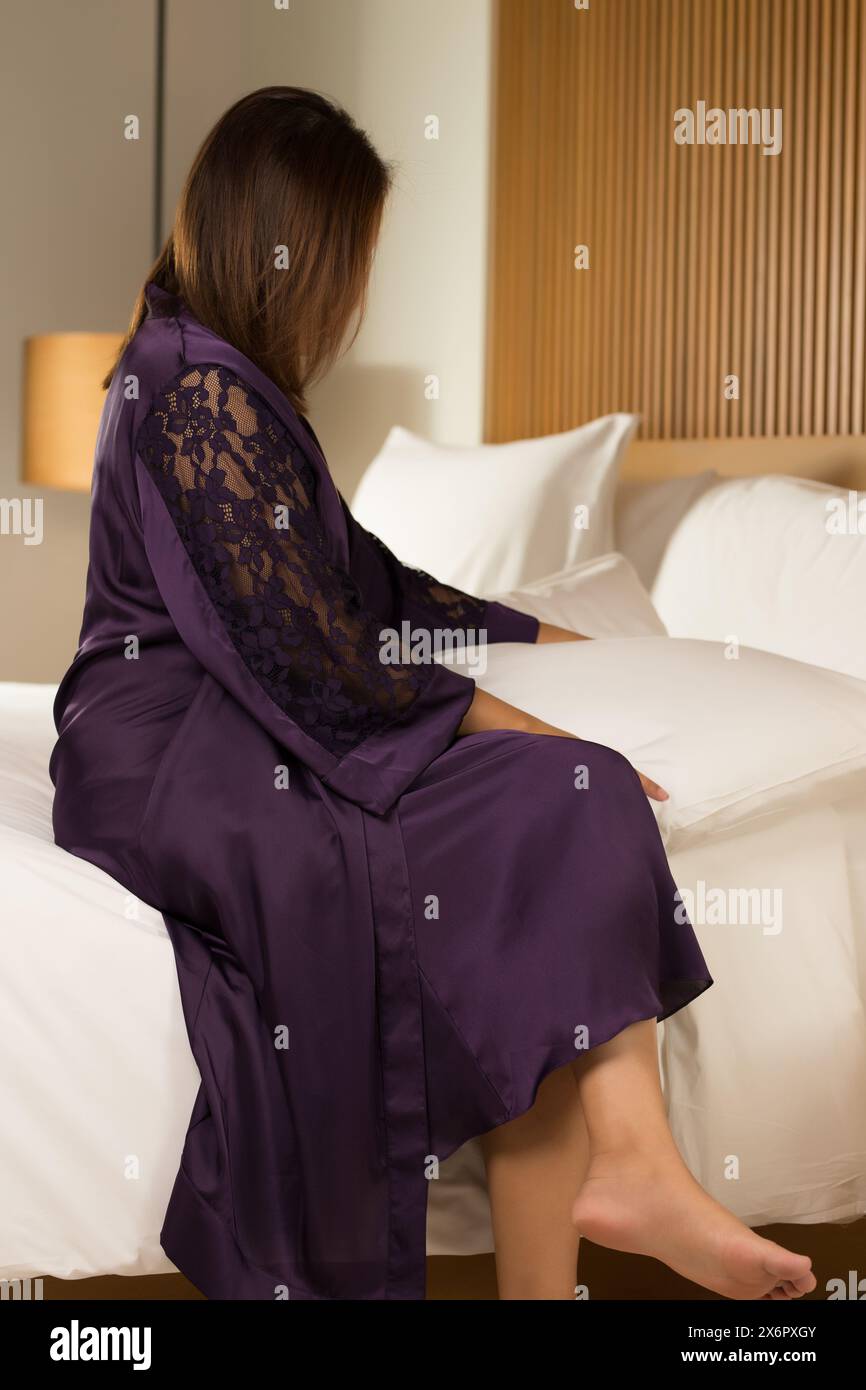 A moment of serene repose; a woman in an elegant robe enjoys the soft ...