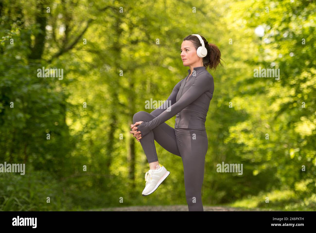 woman doing leg stretching exercises before running and jogging in the ...