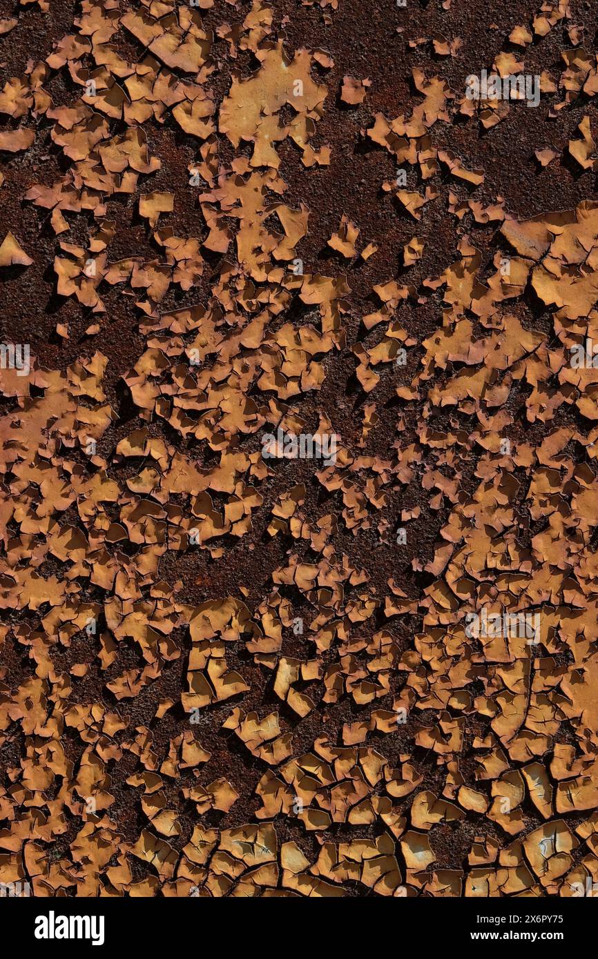 A close-up view of a rusted, peeling paint surface on metal, showcasing the texture and decay ...