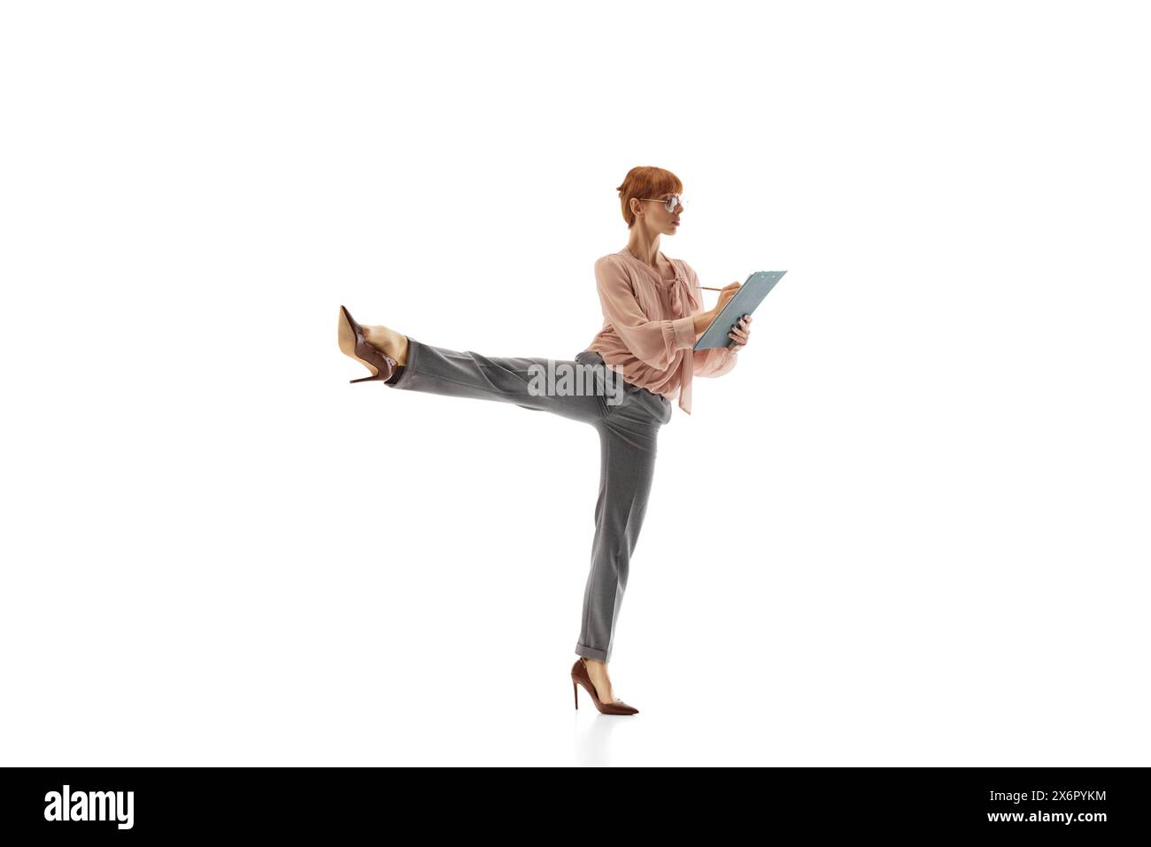 Focused and concentrated woman, employee in formal wear making notes in ...