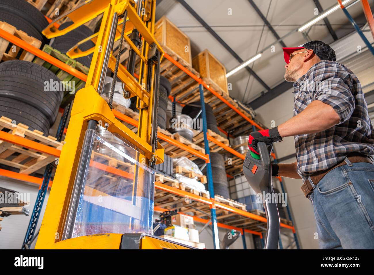 Man using forklift equipment in a warehouse setting Stock Photo - Alamy