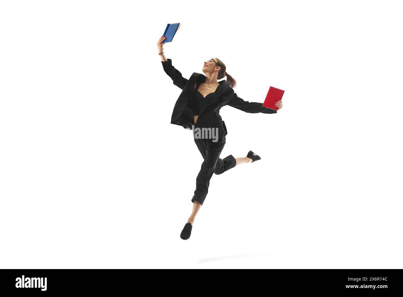 Businesswoman in mid-air pose, reading book in a jump, showcasing ...