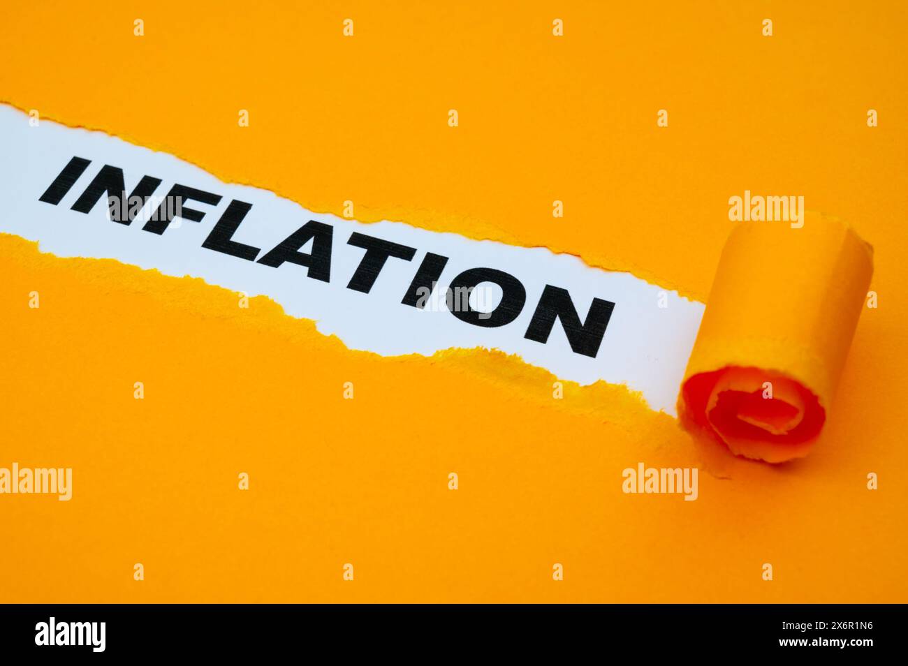 White surface, with the word Inflation in black, underneath torn and ...