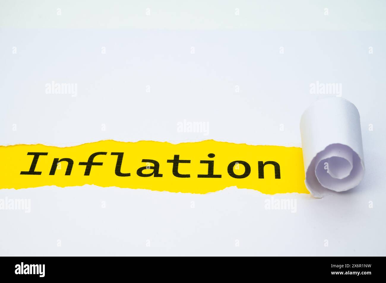 Yellow surface, with the word Inflation in black, underneath torn and ...