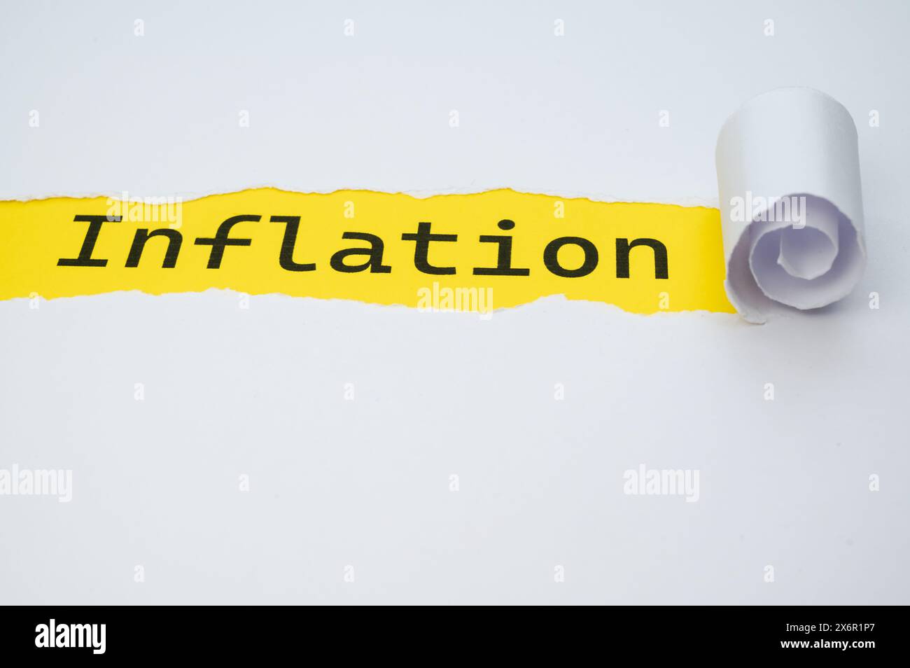 Yellow surface, with the word Inflation in black, underneath torn and ...