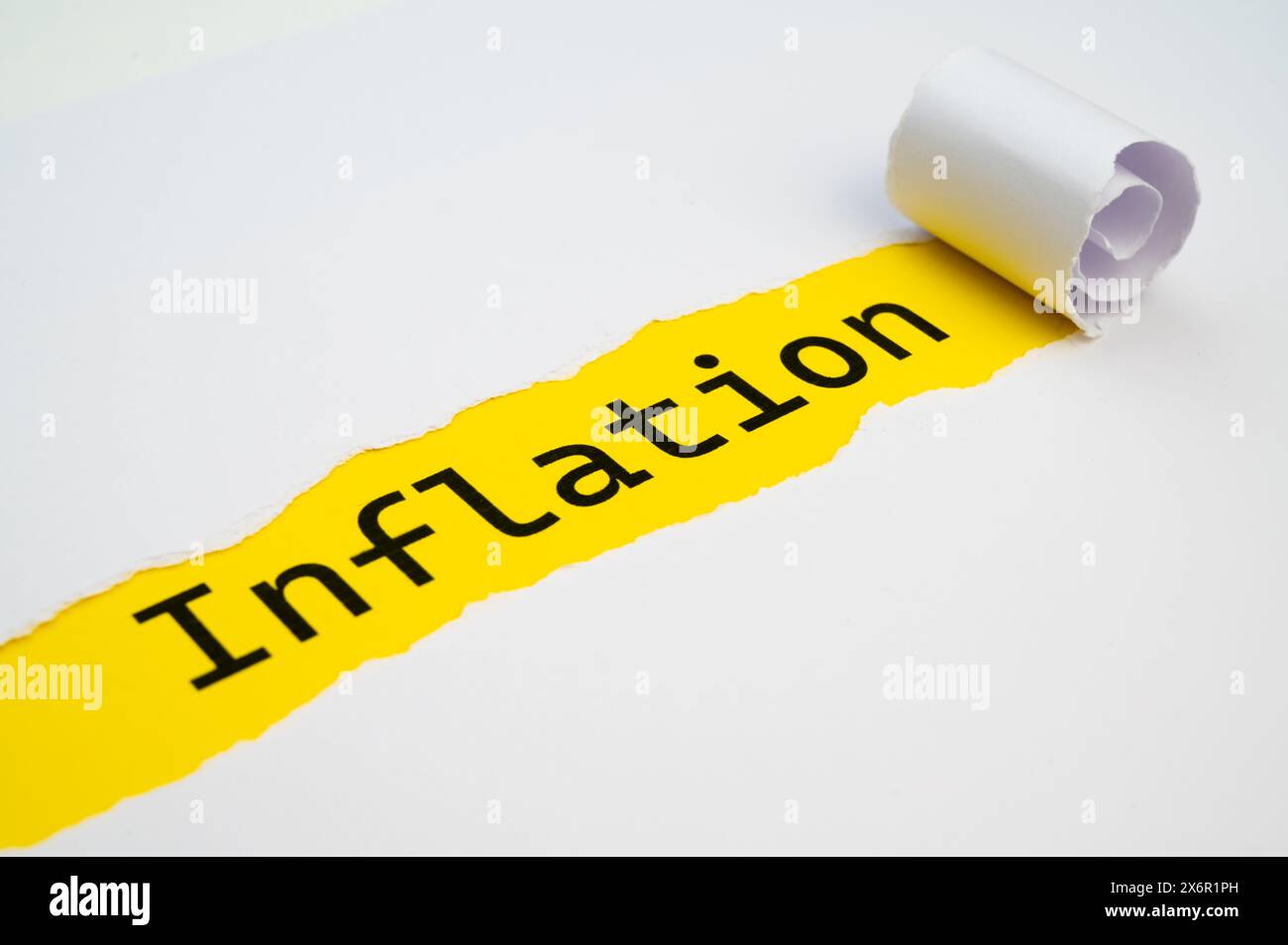 Yellow surface, with the word Inflation in black, underneath torn and ...