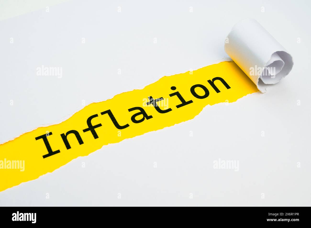 Yellow surface, with the word Inflation in black, underneath torn and ...