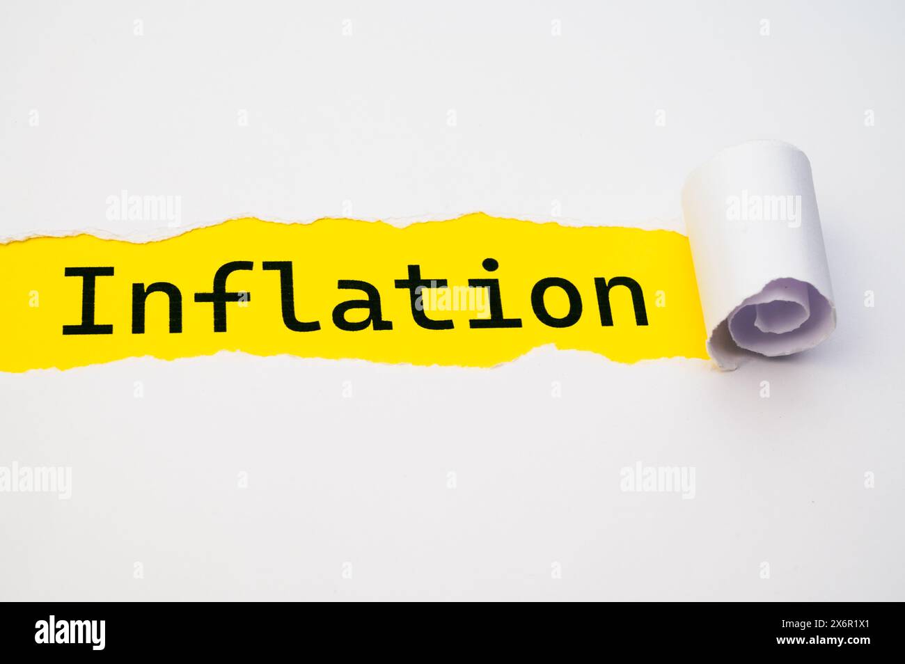 Yellow surface, with the word Inflation in black, underneath torn and ...
