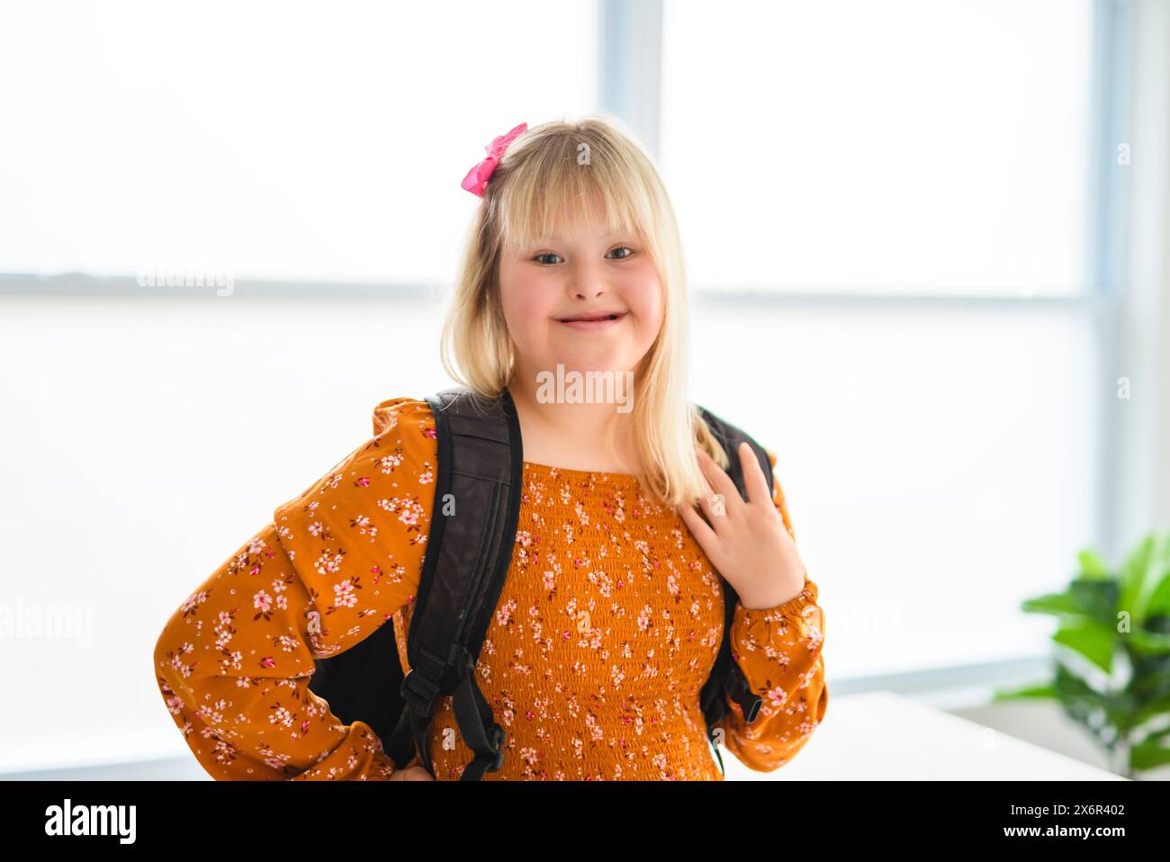 Woman with down syndrome wearing student backpack at school Stock Photo ...