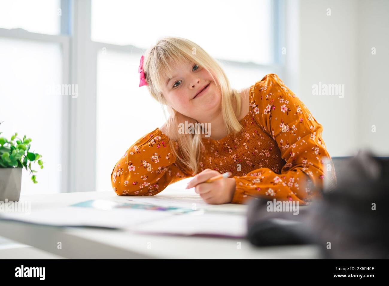 portrait of a girl with down syndrome drawing and smiling happily while ...