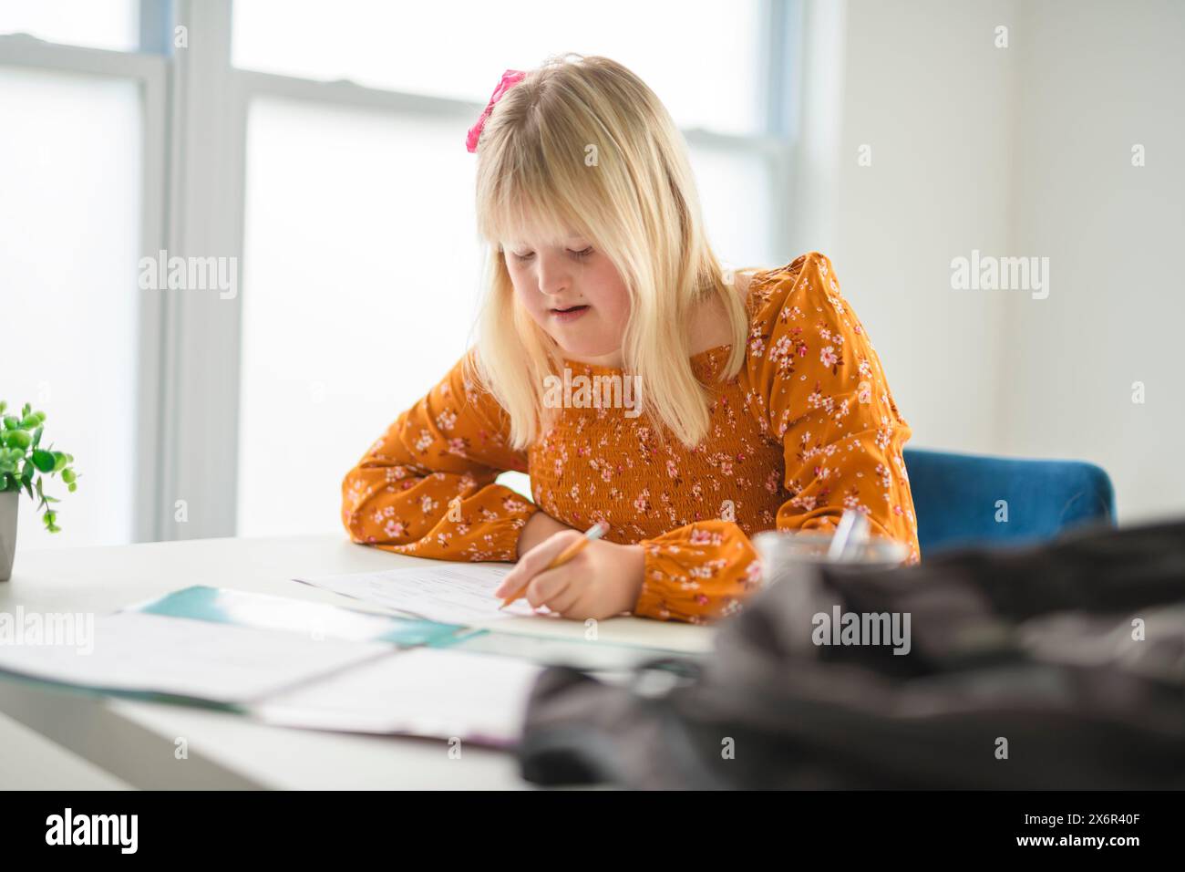 portrait of a girl with down syndrome drawing and smiling happily while ...