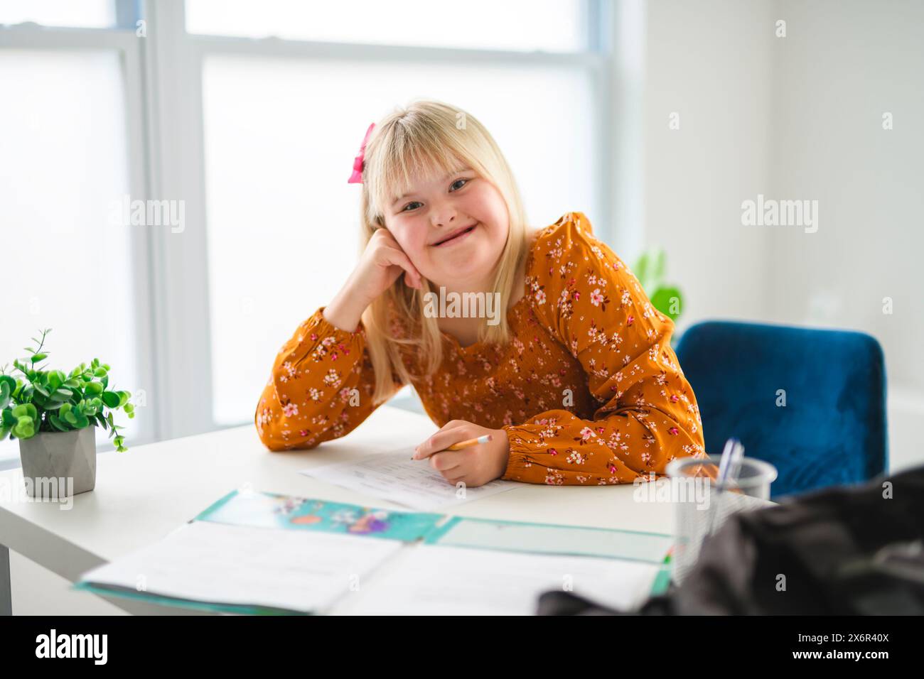 portrait of a girl with down syndrome drawing and smiling happily while ...
