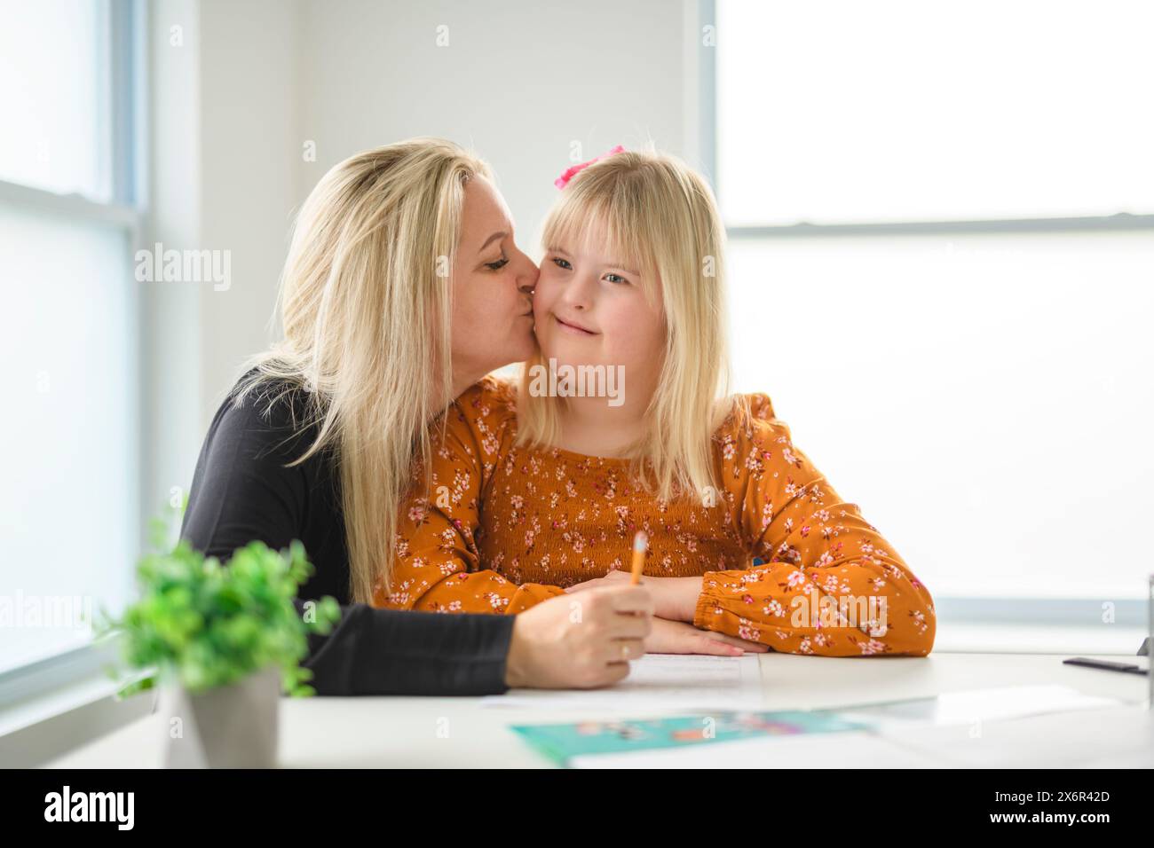 mother and girl with down syndrome drawing and smiling happily while ...