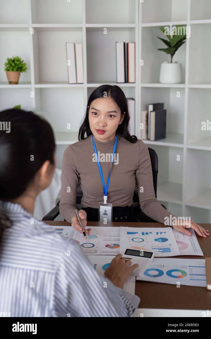 Asian businesswomen analyzing charts in a modern office. Concept of ...