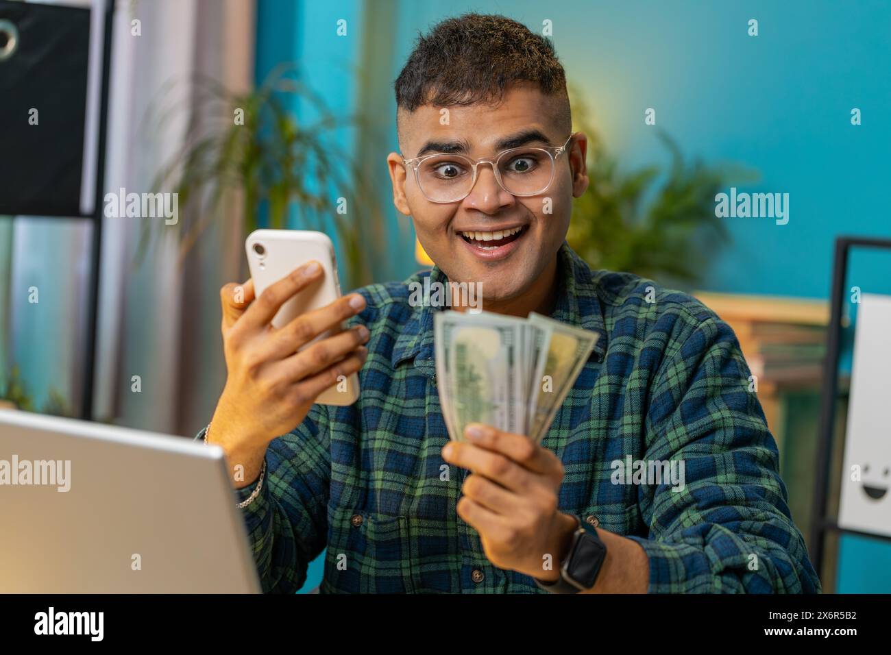 Planning family budget. Amazed happy Indian man counting money cash use ...