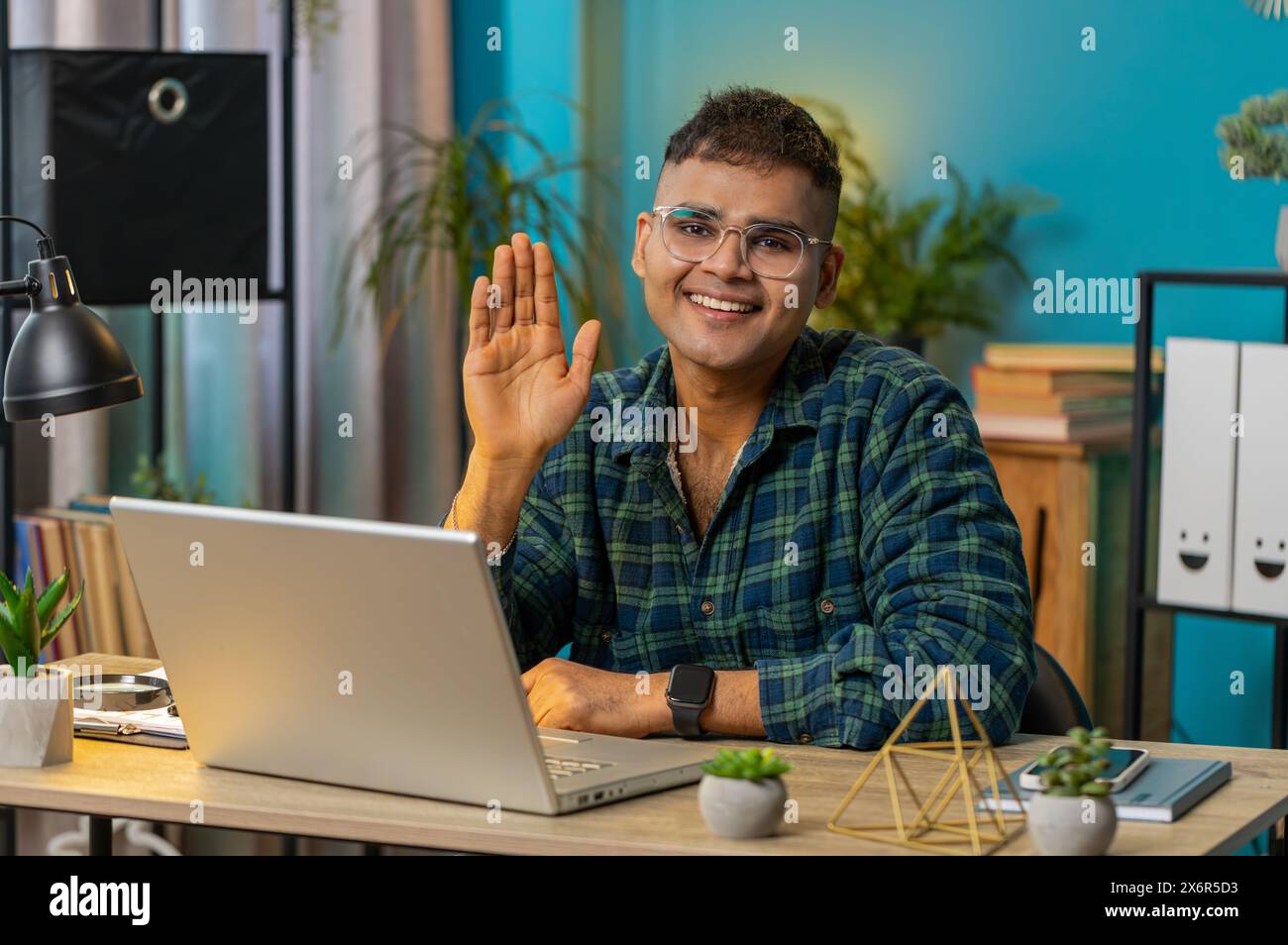 Hello. Indian man smiling friendly at camera and waving hands gesturing ...