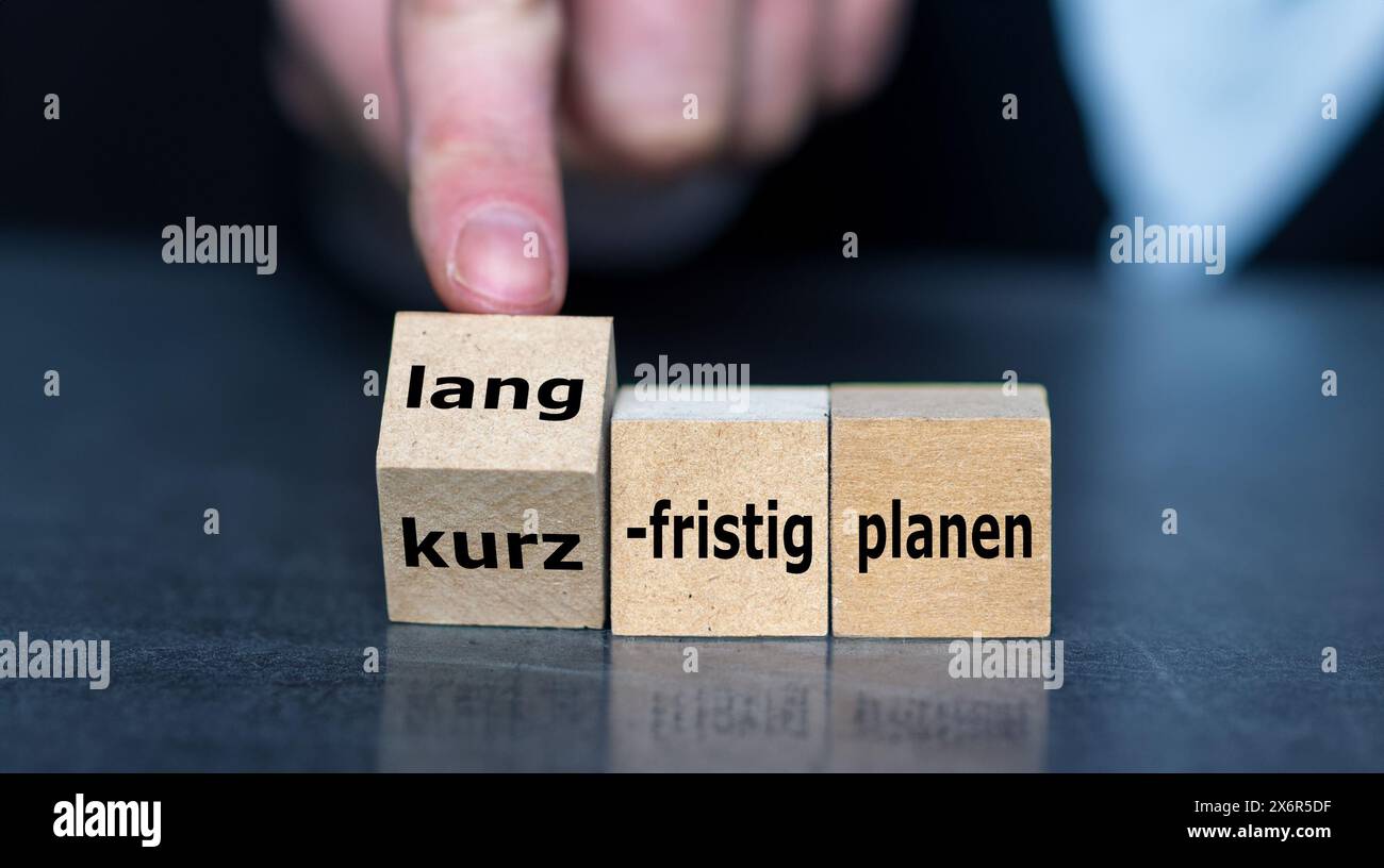 Hand turns cube and changes the German expression 'kurzfristig planen ...