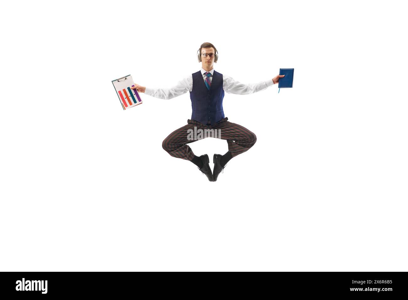 Balance and productivity. Businessman in headphones, in mid-air yoga ...