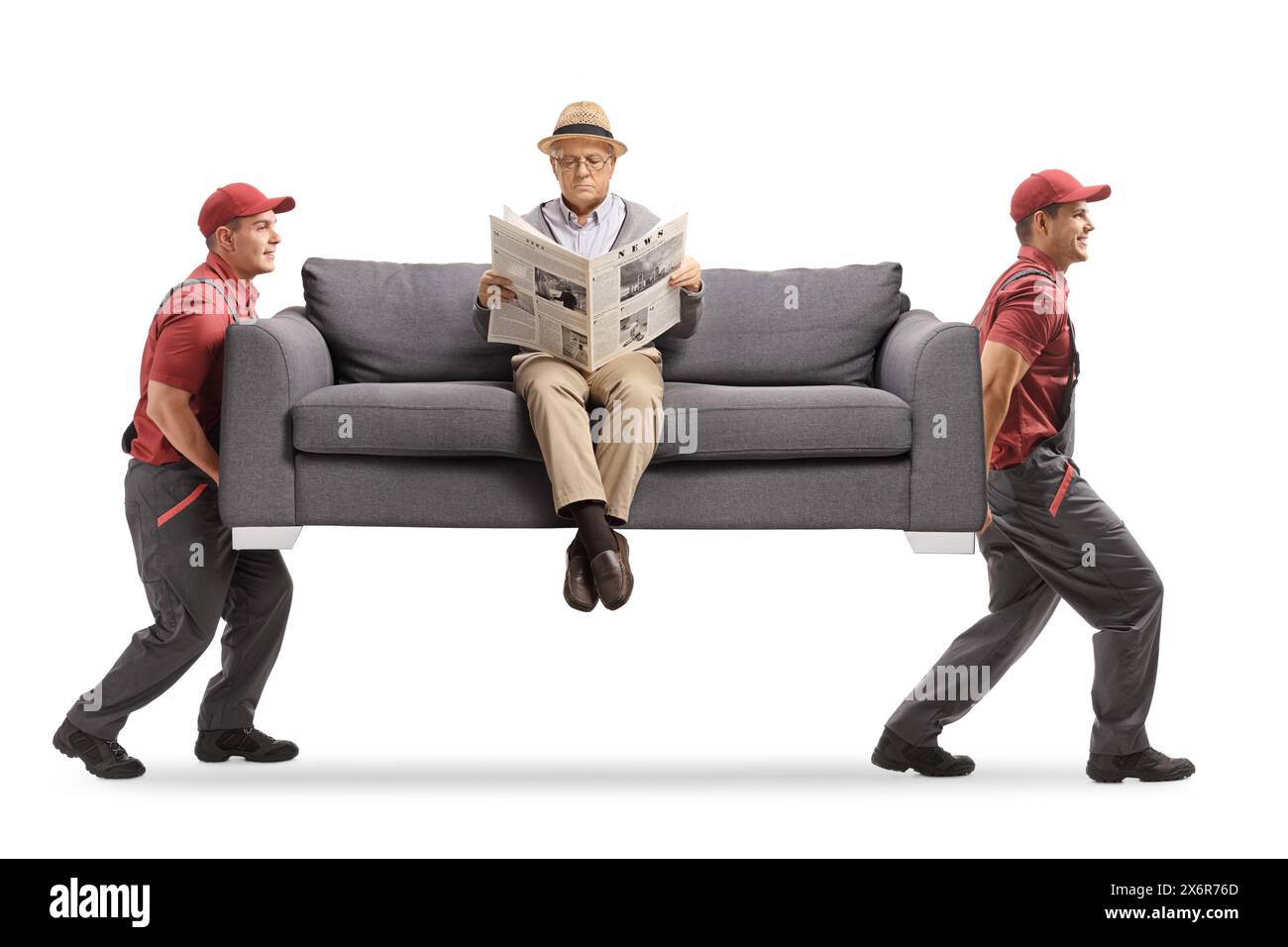 Movers carrying a sofa with an elderly man sitting and reading a ...