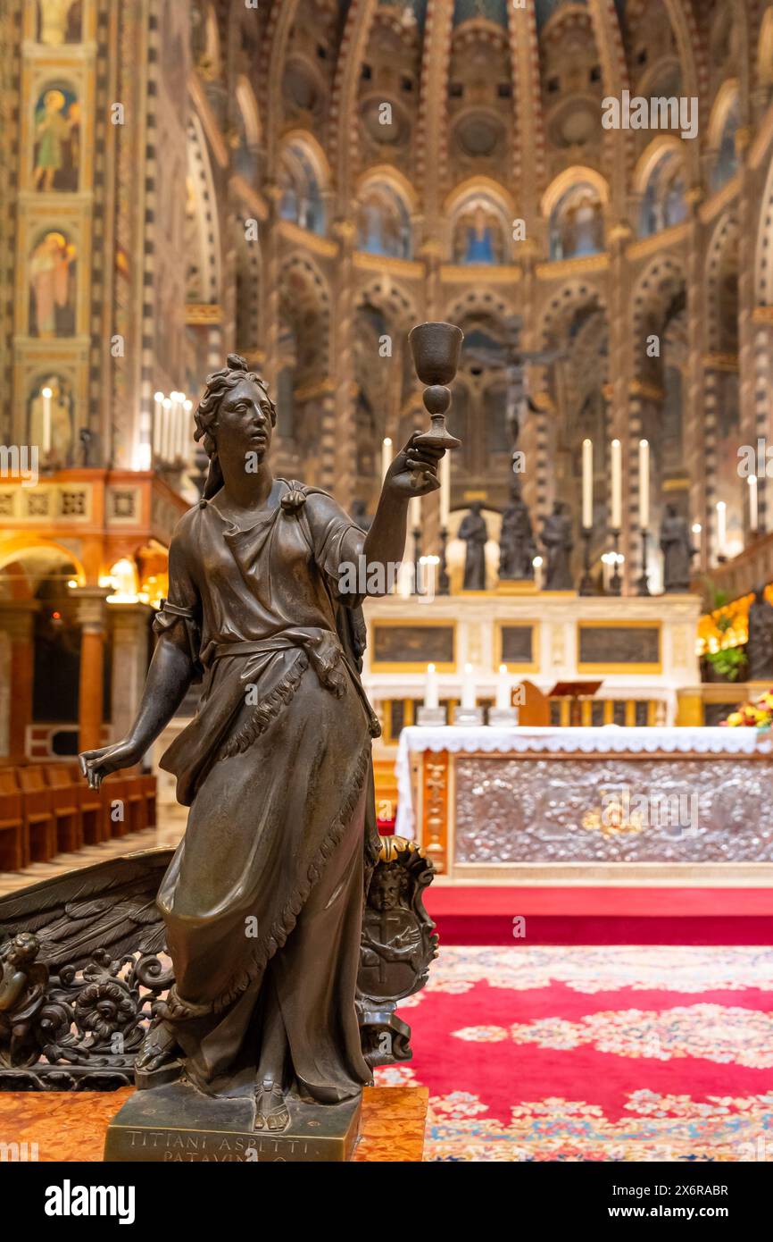 Bronze statue of female saint holding a chalice decorating the interior ...