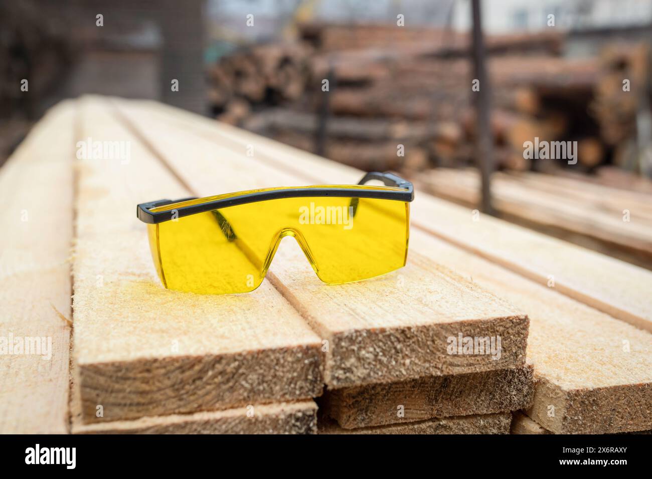 Construction safety goggles on wood planks of sawmill. Woodworking ...