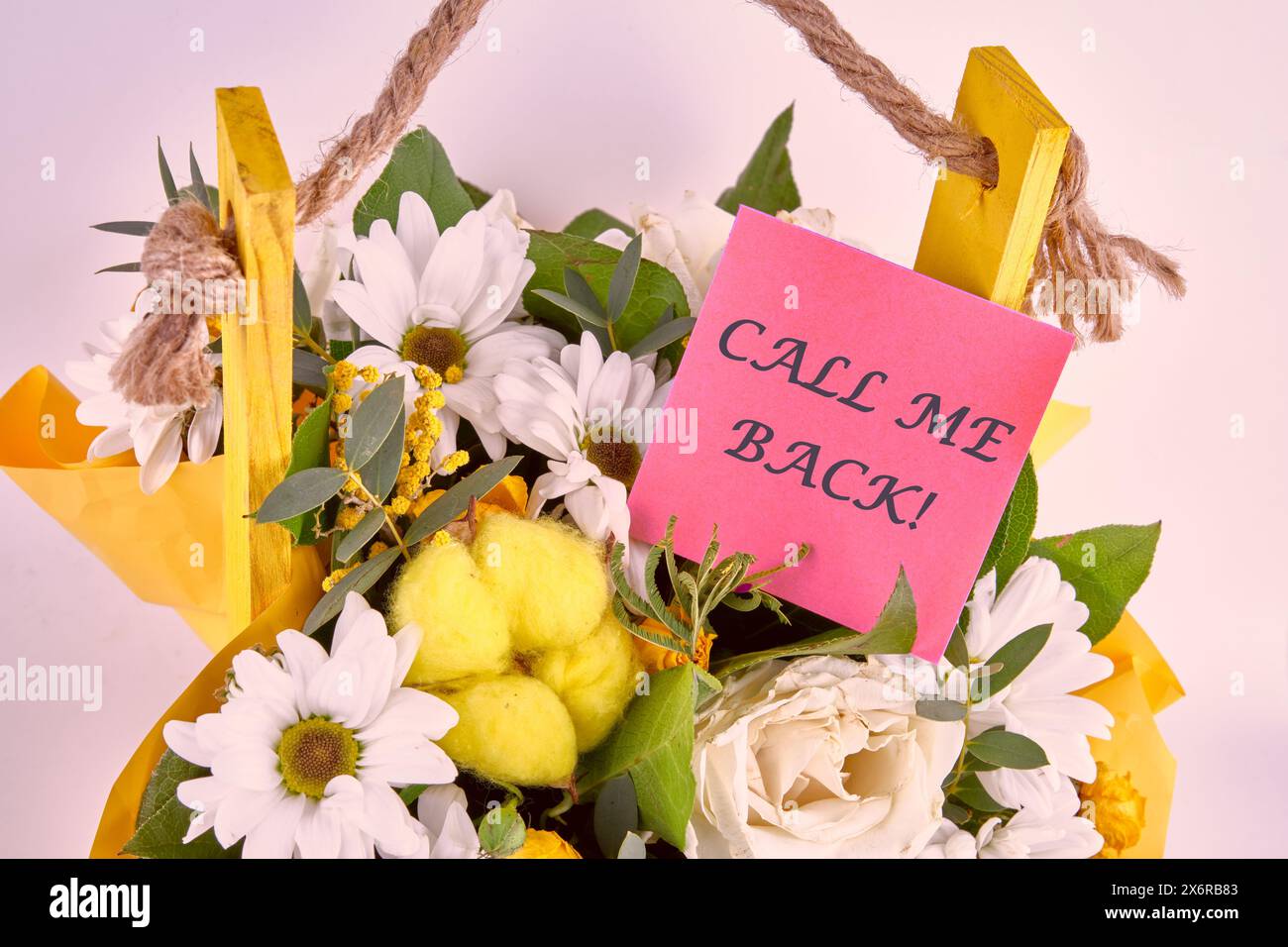 CALL ME BACK text written on a red sticker in a basket with flowers ...