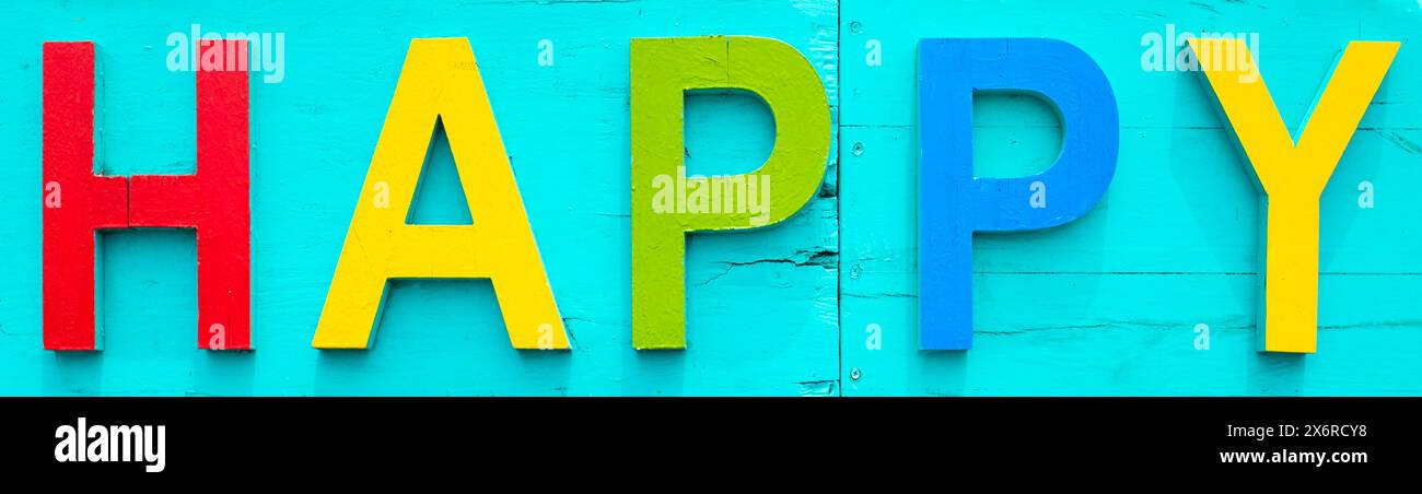 Colorful letters with a word happy, text made with wooden background ...