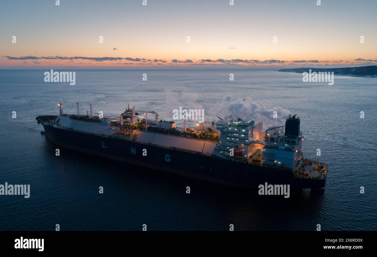 A large LNG tanker docks at an industrial port terminal for cargo ...
