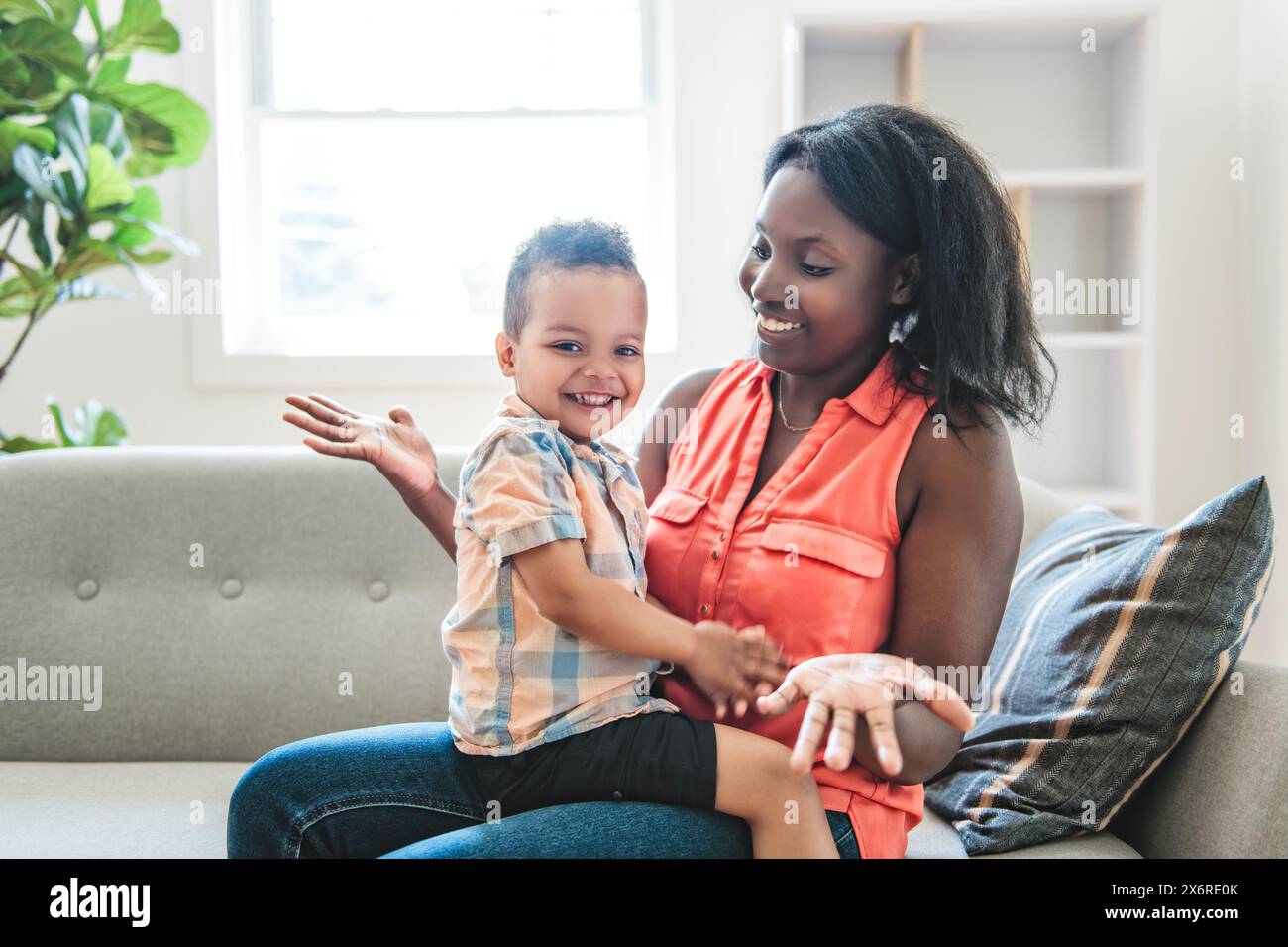 portrait of beautiful young American mother with child boy at home ...