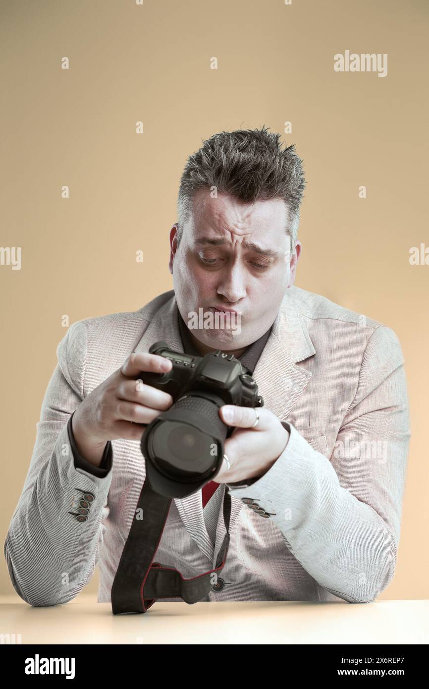 Critical photographer examines his camera with a meticulous eye ...