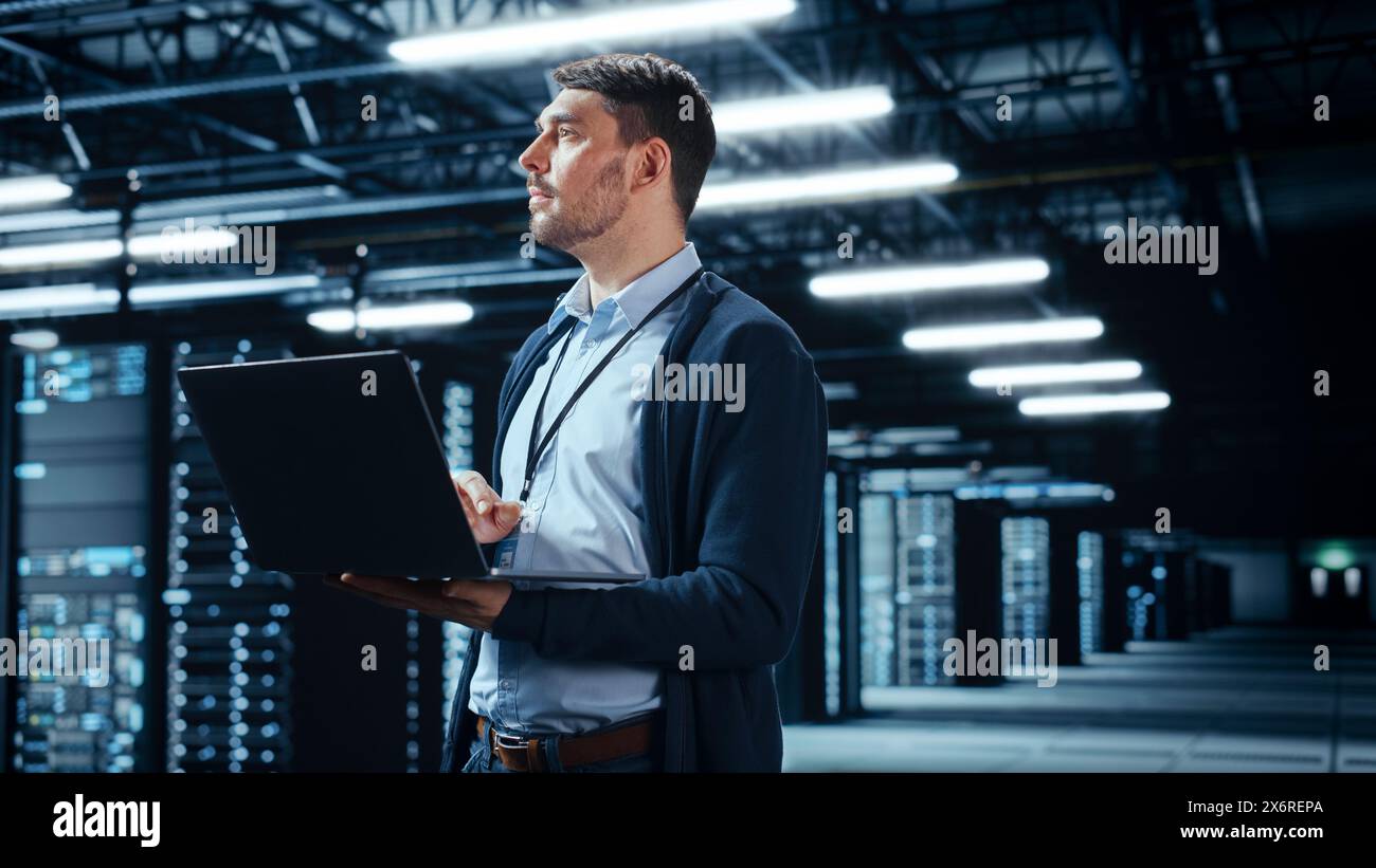 Successful Data Center IT Specialist Using Laptop Computer. Server Farm ...