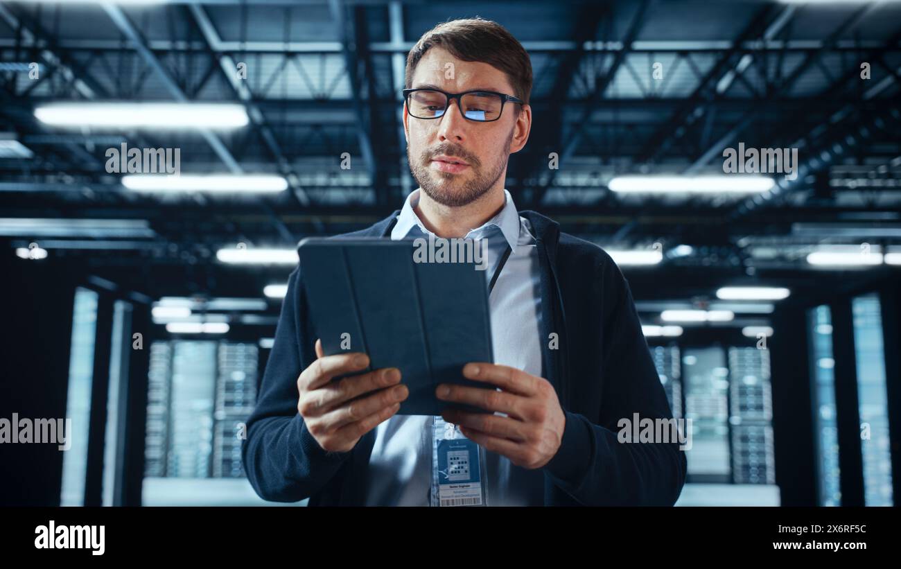 Successful Data Center IT Specialist Using Tablet Computer. Server Farm Cloud Computing Facility ...