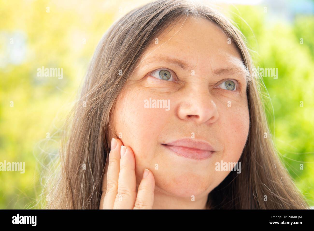 Caucasian positive 50-year-old attractive woman with long hair poses ...
