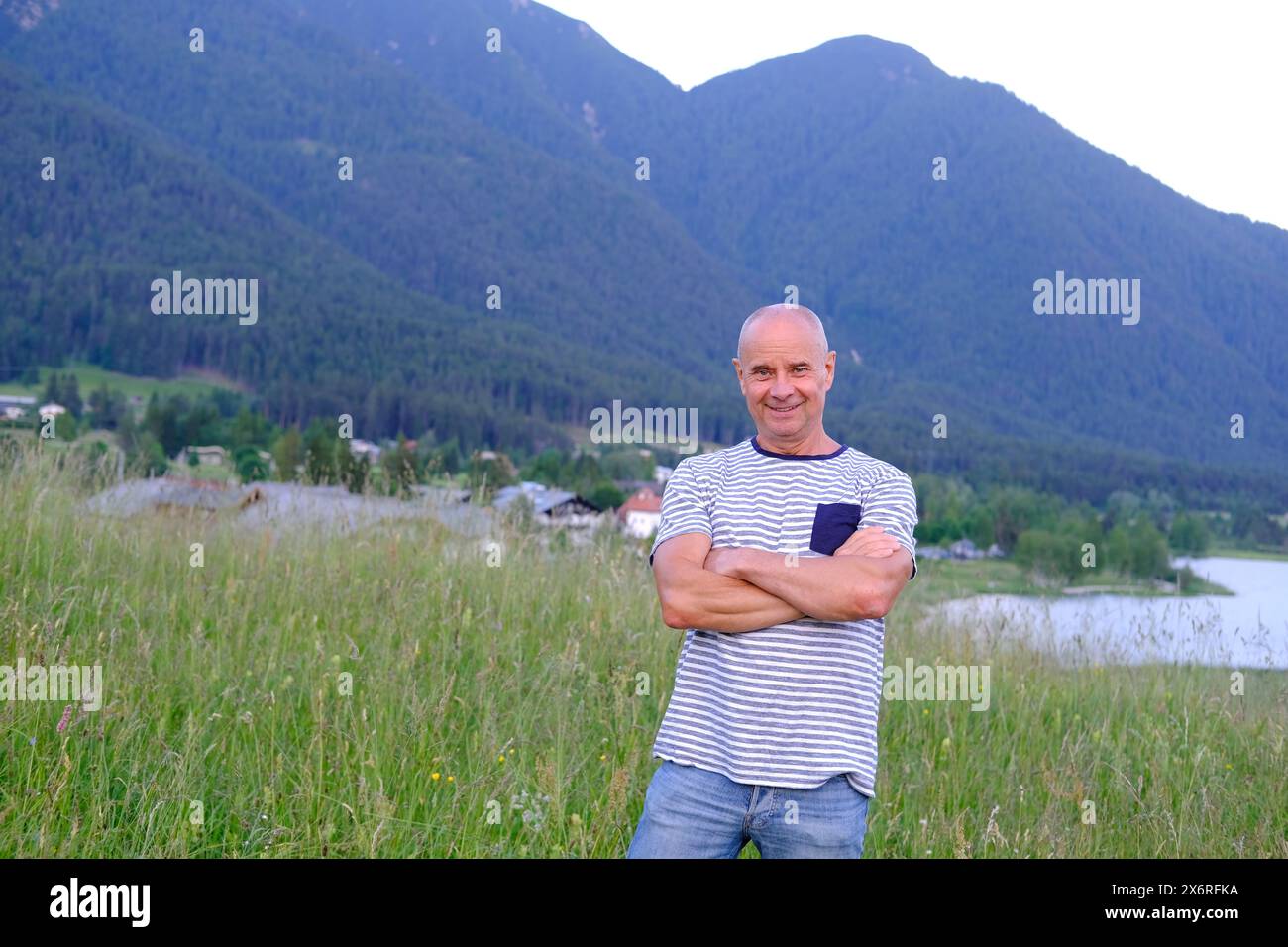mature man, senior 60 years old standing in mountains above city ...