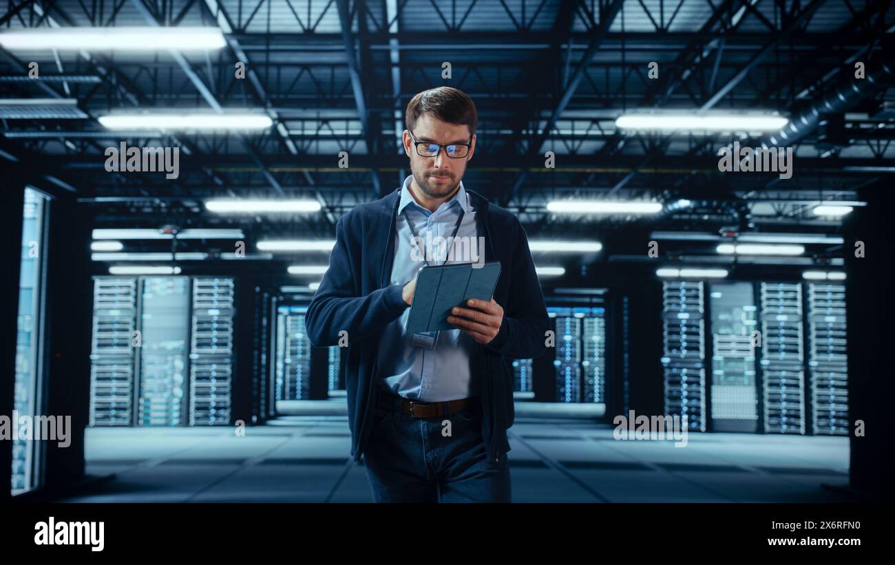 Male IT Specialist Walks Between Row of Operational Server Racks in ...