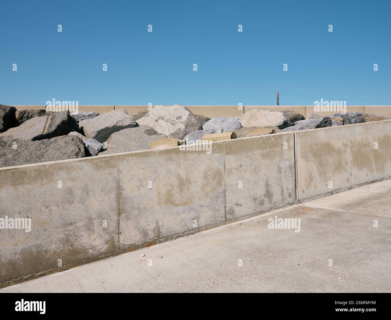 Minimal sea wall defence and blue sky background in Camber East Sussex ...