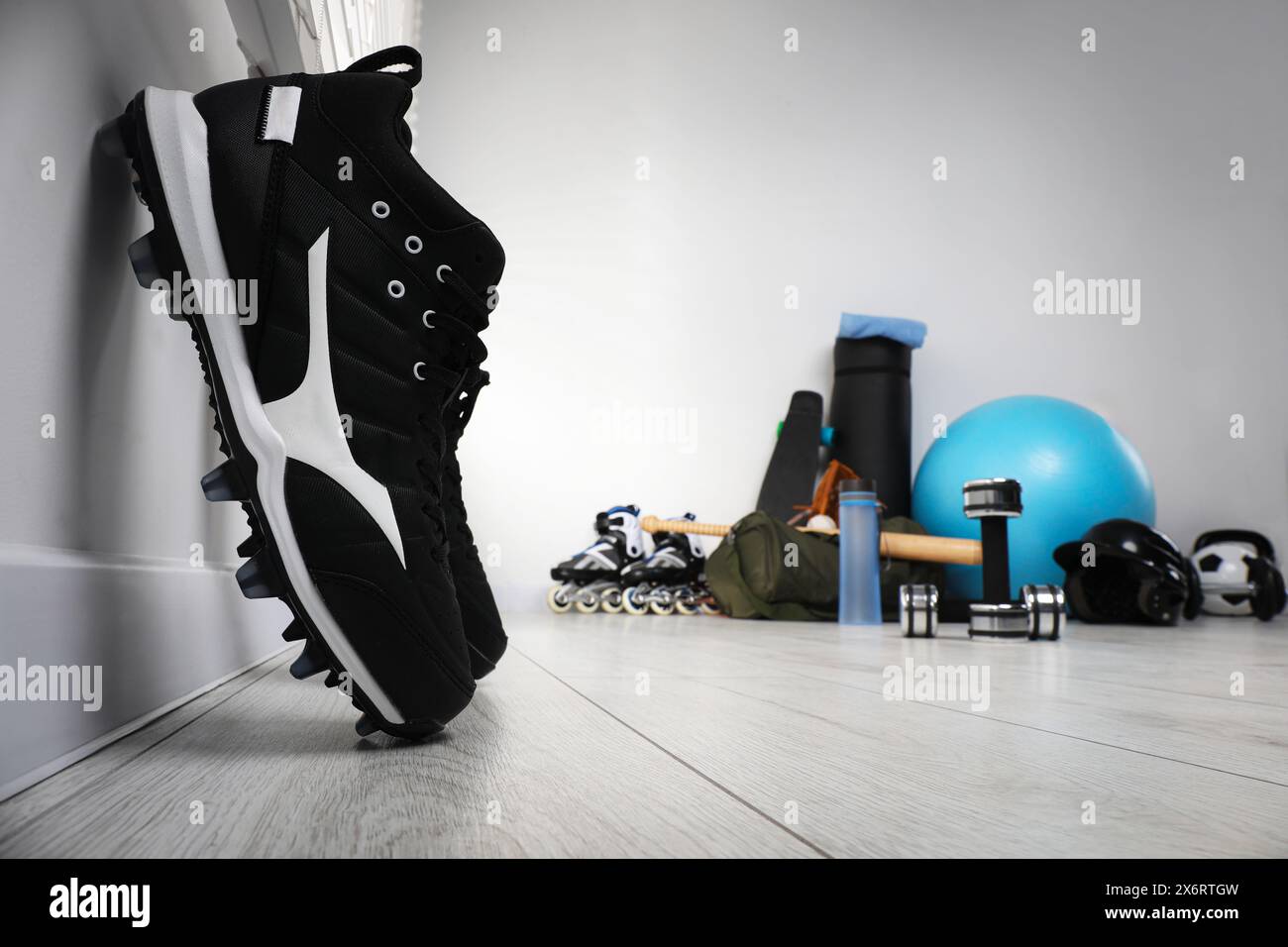 Black snickers and different sports equipment indoors Stock Photo - Alamy