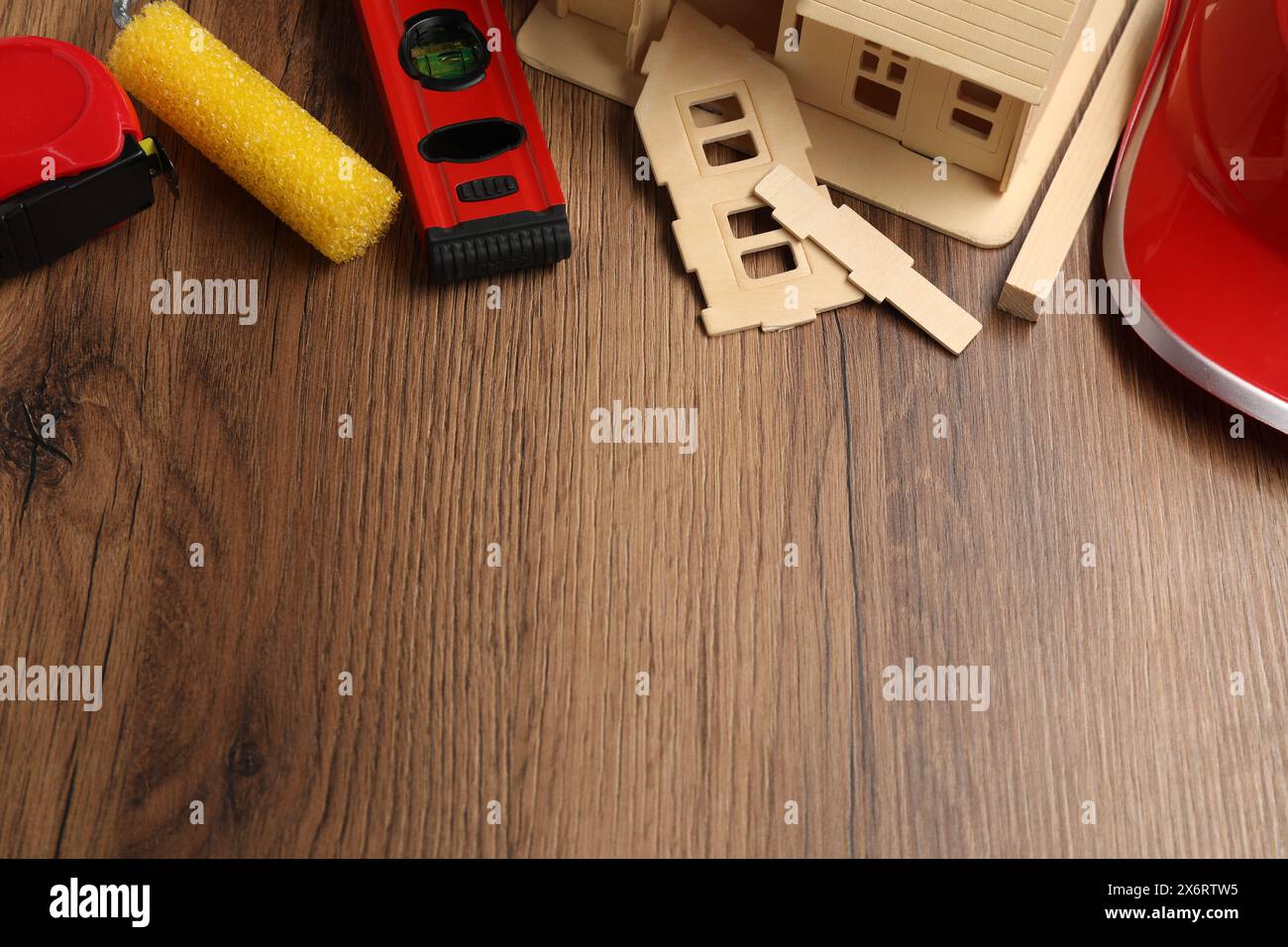 Building level and other construction tools on wooden table, above view ...
