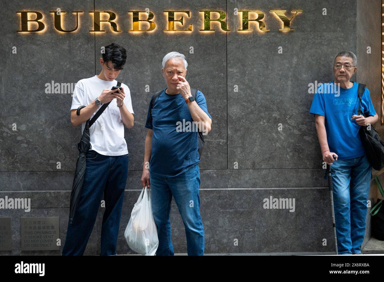 People are seen standing outside the British luxury fashion brand ...